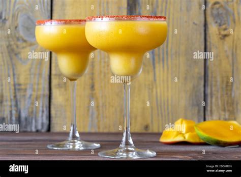 Glasses Of Frozen Mango Margarita Cocktails Garnished With Paprika Salt