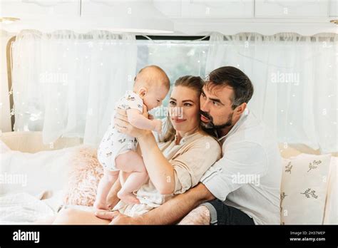 Famille avec bébé sur le lit dans la remorque le matin Enfant nouveau né voyageant en camping