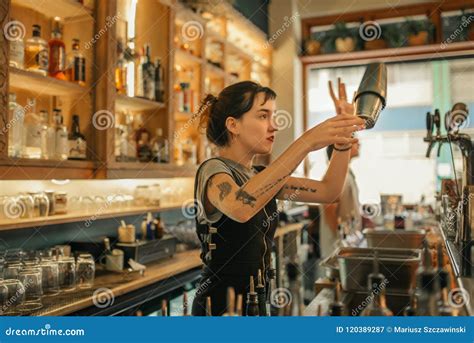 Young Female Bartender Mixing Cocktails Behind A Bar Counter Stock
