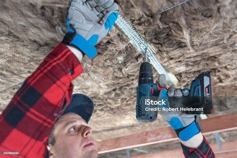 Lowering And Insulate The Ceiling The Worker Working With A Cordless