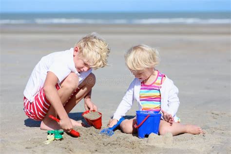 Dos Niños Hermano Y Hermana Jugando En La Playa Imagen De Archivo