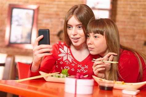 Le Belle Ragazze Mangiano I Rotoli Di Sushi Alla Barra Di Sushi