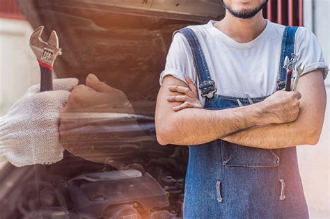 자동차 수리 차고에 자동차 엔진을 고정 유니폼에 잘생긴 역학 자동 서비스에서 작업 하는 동안 자동차 수리는 이중 노출 색상 효과입니다 다중 노출에 대한 스톡 사진 및 기타