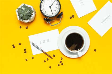 블랙 커피 한 잔 커피 콩 검은 알람 시계 펜 노란색 배경 에 흰색 종이 카드 플랫 누워 상단 보기 복사 공간 크리에이티브 컨셉 타임 워크 여성 데스크탑 커피 배경 갈색에