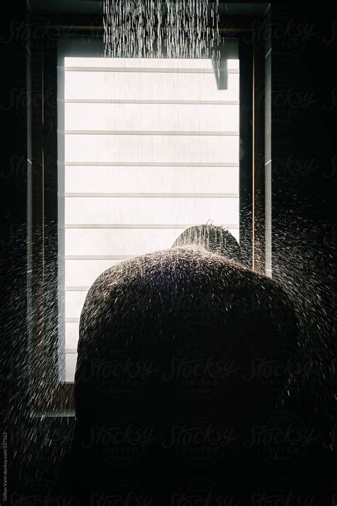 Silhouette Of Man In The Shower With Water Hitting His Back By