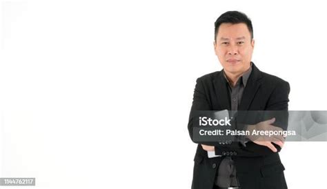 잘 생긴 웃는 사업가는 흰색 배경에 고립 된 교차 팔과 함께 서 있는 모바일 장치를 들고 소송에서 경영자에 대한 스톡 사진 및
