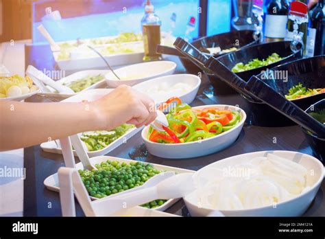 Asian Woman Choosing Vegetable Ingredients At Salad Bar Buffet