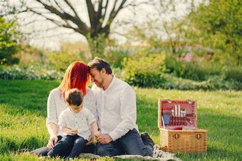 Free Photo Redhead Mom In A White Blouse Sits On The Grass With Her