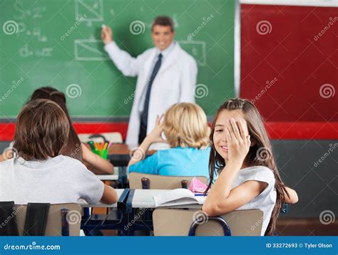 Girl Covering One Eye While Sitting At Desk Stock Image Image Of