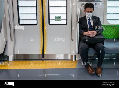 A Japanese Male Office Worker Or Salaryman Wearing A Face Mask