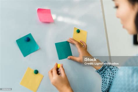 사무실에서 화이트 보드에 다채로운 스티커 메모를 두 여자의 보기를 자른 부분의에 대한 스톡 사진 및 기타 이미지 부분의