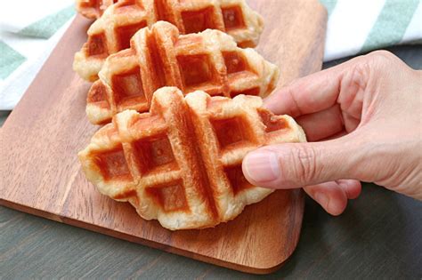 브레드보드에서 맛있는 갓 구운 크로플 또는 크루아상 와플 따기 갈색에 대한 스톡 사진 및 기타 이미지 갈색 남자 남자들만