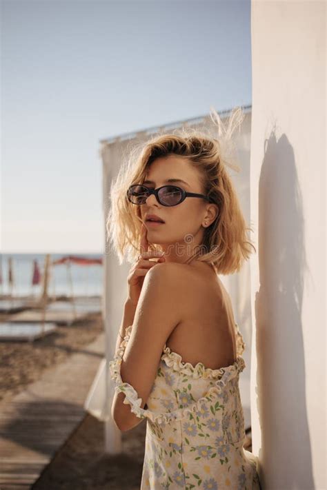 Seductive Slender Caucasian Young Lady Stands Half Sideways Near White