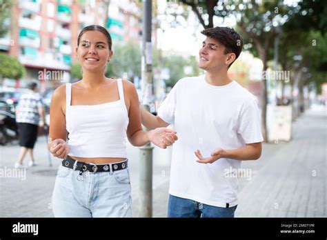Cheerful Guy Trying To Pick Up Young Stranger Girl On City Street Stock