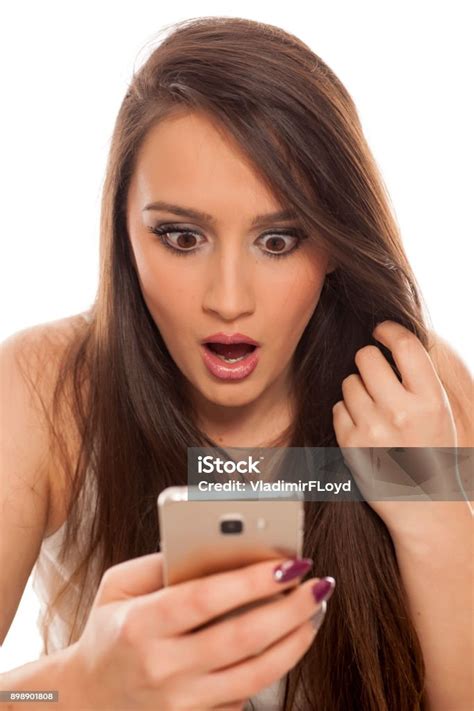 白い背景の上の彼女のスマート フォンで見てショックを受けた若い女性 1人のストックフォトや画像を多数ご用意 1人 カジュアルウェア