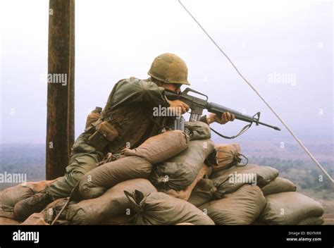 A Soldiers Of The 4th Infantry Division Ivy Points An M 16 Rifle From