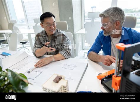 Architects Working With 3D Printer And Projecting House Model Drawing