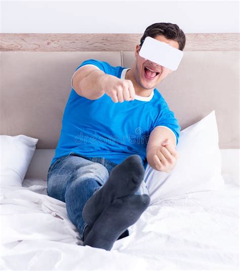 Young Man In Bed Wearing A Vr Virtual Reality Head Set Stock Image