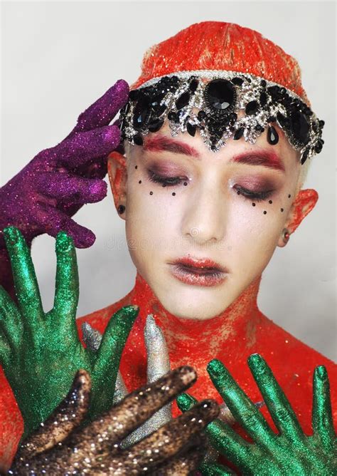 Modelo Del Hombre En El Maquillaje Rojo Del Arte Con Los Ojos Verdes