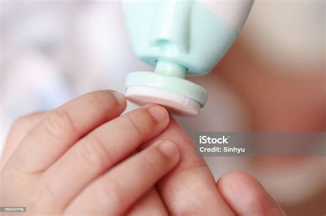 네일 파일로 손톱을 잘라 어머니는 자동 아기 손톱 파일 기계를 사용 하 여 아기 손톱을 작성 합니다 가위에 대한 스톡 사진 및 기타 이미지 Istock