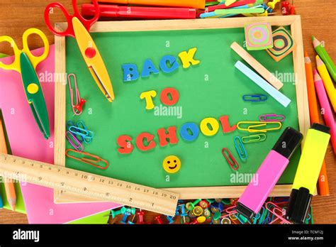 Small Chalkboard With School Supplies On Wooden Background Back To