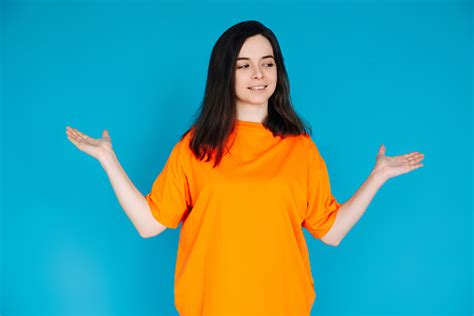 손바닥에 빈 복사 공간을 들고 웃고 있는 젊은 여성 밝은 파란색 배경에 고립된 매력적인 여성 모델 인물 사진 20 24세에 대한