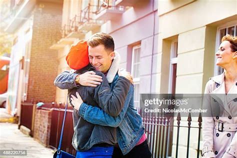 Two Friends Reunite On Street In Front Of Happy Girlfriend High Res