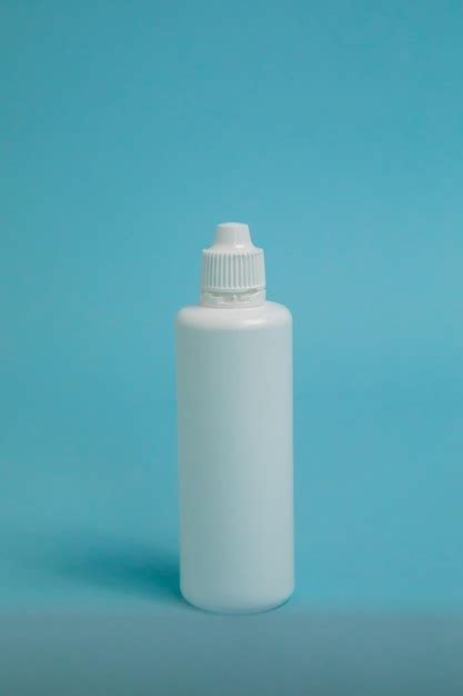 Una botella de líquido para lentes sobre un fondo azul mock up de