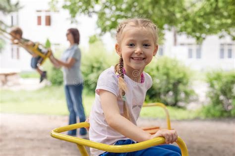 Portrait Of A Beautiful Girl On The Playground On A Swing Stock Image