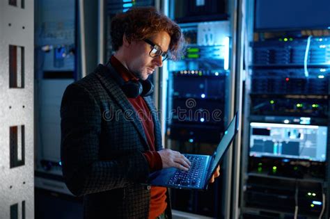 It Technician Checking The Servers Vitals Using Laptop Computer Stock
