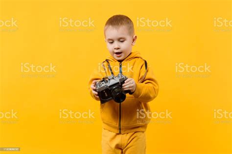 작은 아이 소년 34 세 노란 옷을 입고 카메라 오렌지 벽 배경 어린이 스튜디오 초상화에 고립 된 개최 사람들은 진심으로 감정