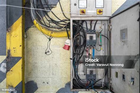 위험한 삼상 220v 전기 차단기 강철 캐비닛 배선이 깔끔하지 않고 전원 연결 상자가 외부 시멘트 벽에 부착되어 있습니다 전기 연료 및 전력 생산에 대한 스톡 사진 및 기타