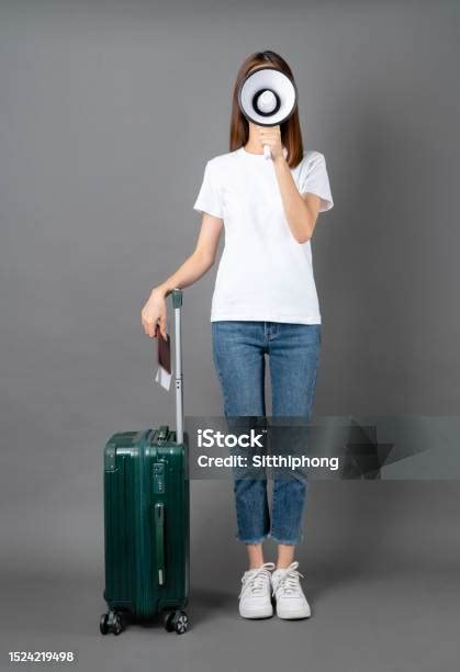 행복한 아시아 여성 여행자는 파란색 배경에 격리된 여행 가방과 함께 여권과 비행기 티켓이 있는 확성기를 들고 서 있다 관광객에