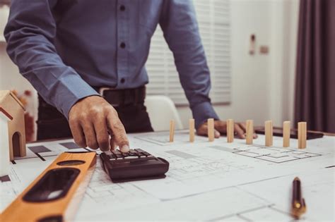 Premium Photo Architect Engineer Using Calculator Estimate Construction Drawings With