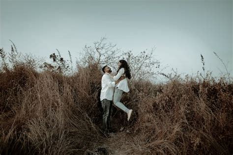 A Couple Standing On Green Grass Field While Holding Hands · Free Stock
