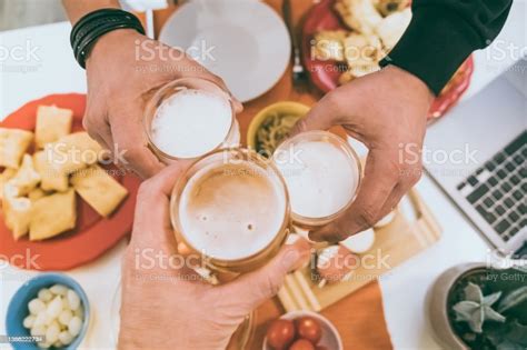 함께 저녁 식사를 즐기는 친구와 함께 토스트 친구들과 여름 감전 많은 음식과 맥주 잔이 있는 테이블 꼭대기에서 가족 관람의