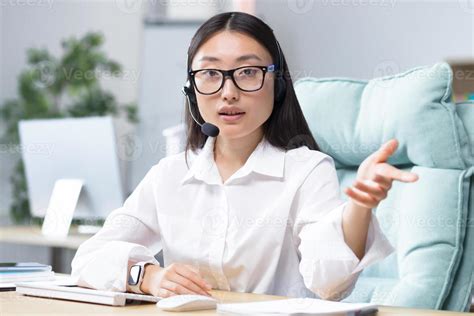 Beautiful Asian Female Bank Support Technician Looking Into Camera And