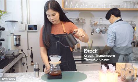 커피숍 사업가인 젊은 여성은 뜨거운 물을 부어 모던 카페 안에서 드리프트 커피를 만든다 손에 대한 스톡 사진 및 기타 이미지