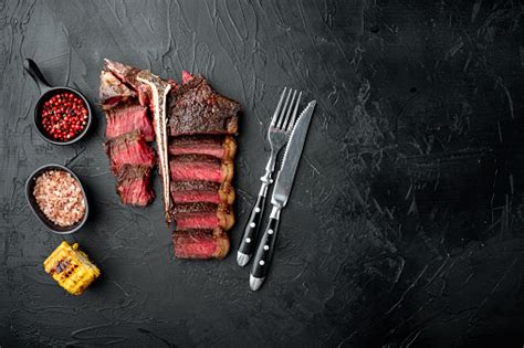 신선한 육즙 매체 희귀 슬라이스 와 구운 T 뼈 또는 포터 하우스 쇠고기 고기 스테이크 검은 돌 배경에 상단 보기 플랫 레이 텍스트복사 공간 바베큐그릴에 대한 스톡 사진 및