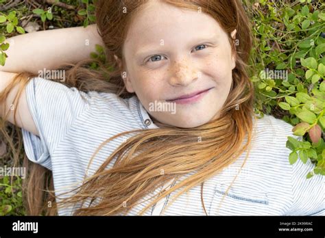 Portrait Of A Red Haired Boy With Long Hair On The Grass Flat Lay The Happy Boy Smiles Copy