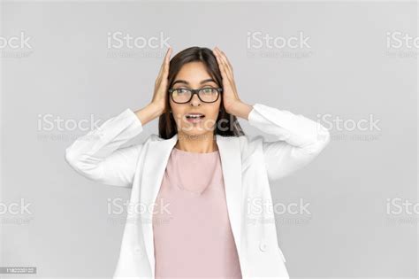 깜짝 놀랄 젊은 성인 인도 사업가 전문 쇼핑객 에 흰색 정장 보고 카메라 손에 손을 잡고 머리에 앉아 깜짝 흥분 서 서 회색