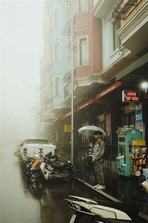 눈 덮힌 땅에 걷는 우산을 들고 검은 자 켓에있는 사람 · 무료 스톡 사진