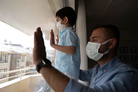 의료 용 마스크를 쓴 아버지와 소년이 창 밖으로 보입니다 25 29세에 대한 스톡 사진 및 기타 이미지 25 29세 2명 35 39세 Istock