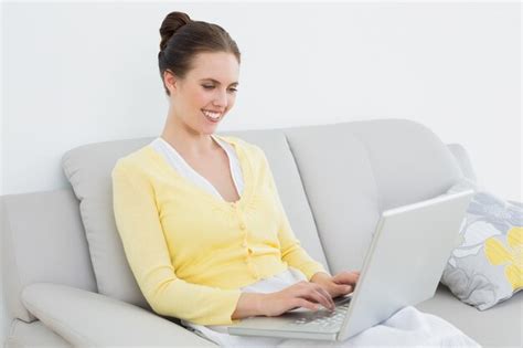 Premium Photo Smiling Casual Woman Using Laptop On Sofa