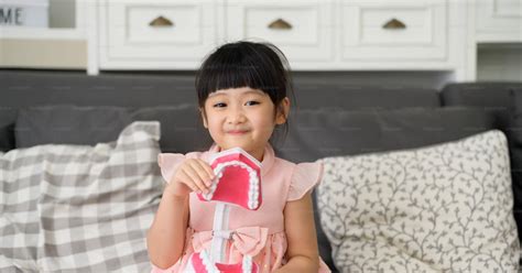 어린 귀여운 소녀가 실내에서 인간 턱의 인공 치과 모델 교육 및 건강 개념을 들고 있습니다 사진 Unsplash의 치통 이미지