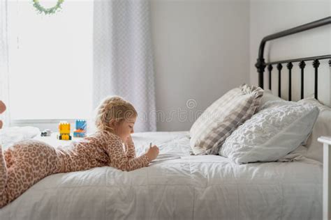 Ni A Que Se Acuesta En Una Cama Dibujo En Tableta Digital Imagen De Archivo Imagen De Joven