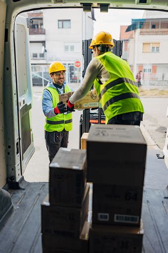 두 명의 창고 작업자가 지게차에서 배달 트럭으로 골판지 상자를 함께 옮기는 팀워크 25 29세에 대한 스톡 사진 및 기타 이미지 25 29세 2명 45 49세