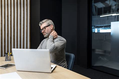 사무실 건물 내부에서 일하는 고위 성숙한 사업가 손으로 목에 아프고 피곤한 회색 머리 남자 목과 등에 심한 통증이있는 상사 40 44세에 대한 스톡 사진 및 기타 이미지