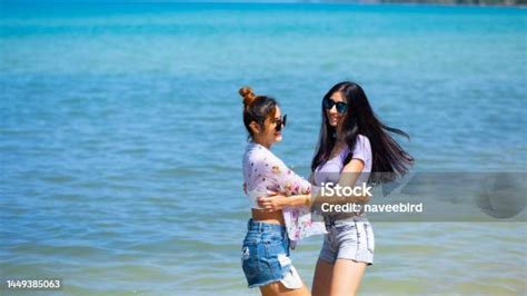 Lgbt 레즈비언 커플은 행복 개념을 좋아합니다 두 명의 아름다운 젊은 여성이 해변에서 함께 포옹하고 함께 걷고 있다 휴가 여행