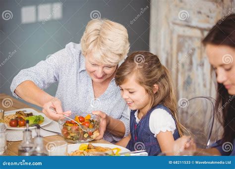 Grandmother Serving Granddaughter While Having Breakfast Stock Image